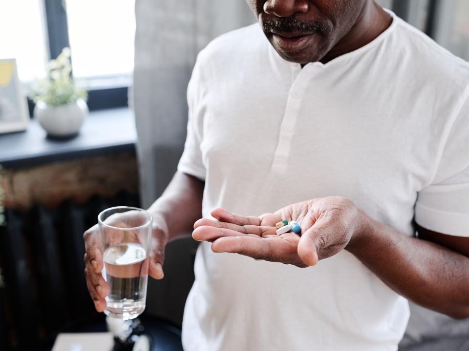 middle-aged Black man taking tablets | Irish Cancer Society